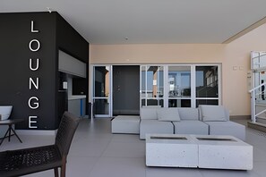 Uma sala de estar moderna com um sofá, uma mesa de centro e uma poltrona.