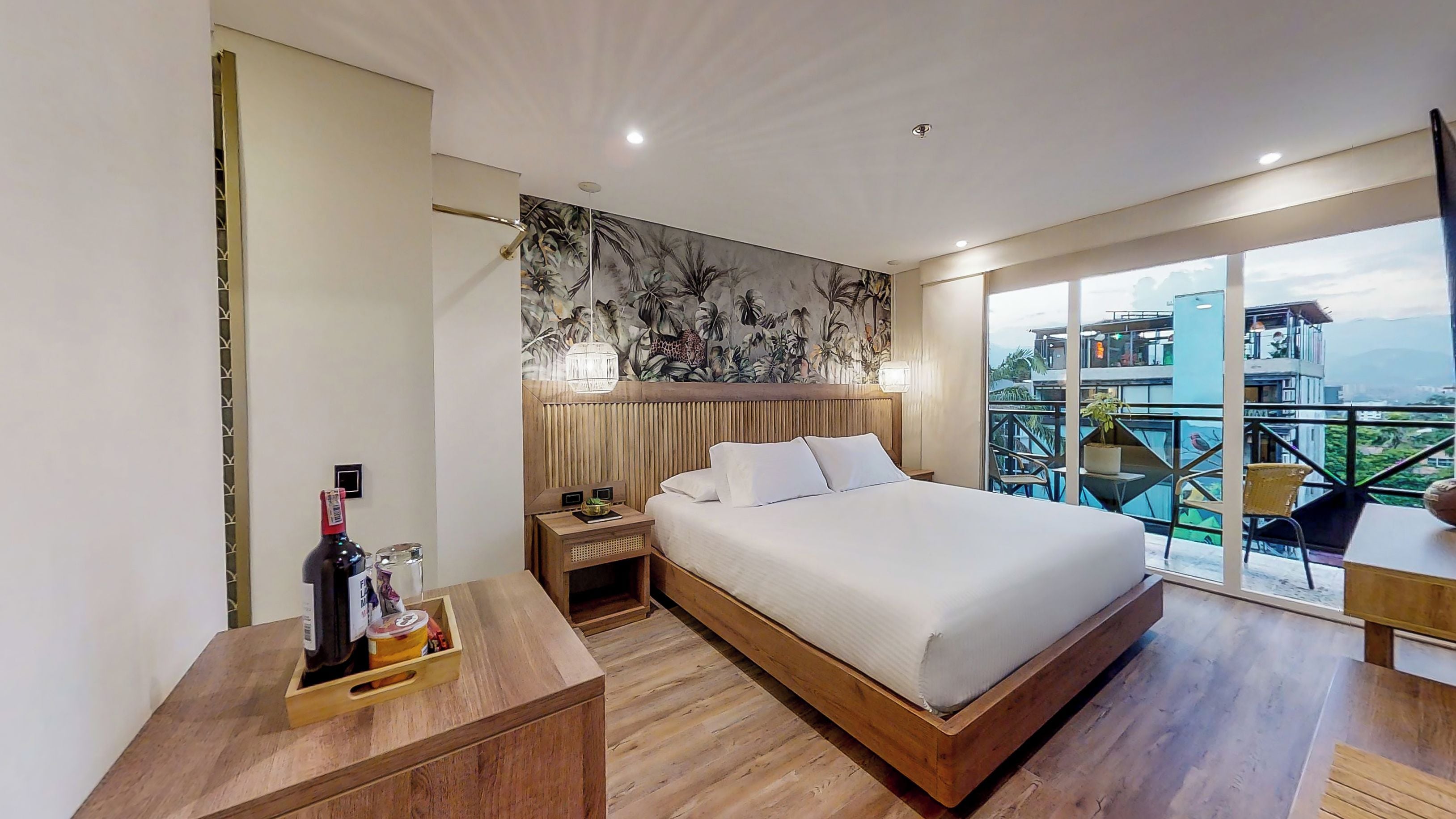 Quarto moderno com cama grande, cabeceira de madeira e vista para uma varanda com área de estar ao ar livre.