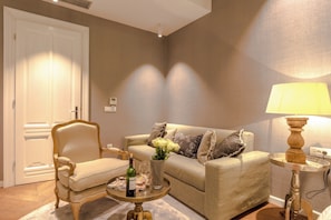 Sala de estar com sofá, poltrona, mesa de centro e abajur.