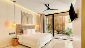 Quarto de hotel moderno com cama, ventoinha no teto, televisão e vista para o exterior.