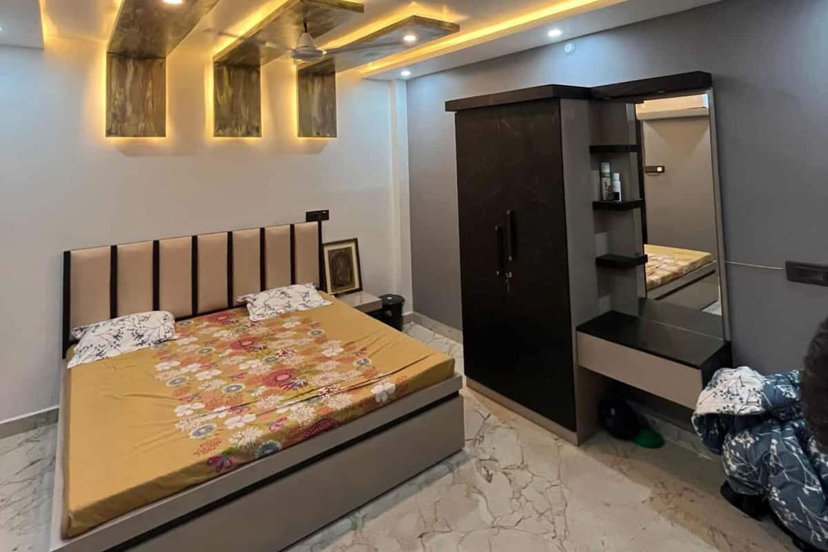 Quarto moderno com cama, guarda-roupa e espelho.