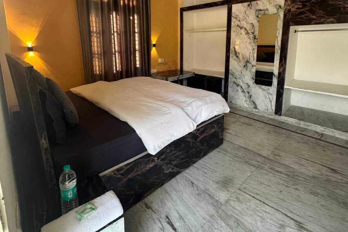 Quarto com cama, ventilador de teto, mesa de cabeceira, espelho e piso de mármore.