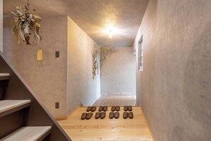 Um quarto de spa com piso de madeira, um telefone fixado na parede e uma planta decorativa.