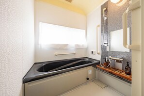 Casa de banho compacta com lavatório, chuveiro e espelho.