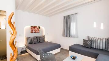 Um quarto moderno com uma cama, um sofá, uma cadeira e uma mesinha.