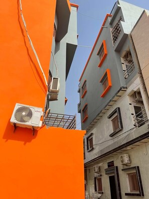 Edifício com várias andares, varandas e aparelhos de ar condicionado.