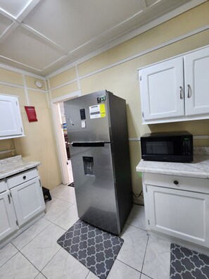 Refrigerador em uma área comum, micro-ondas em uma área comum