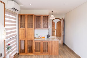 Cozinha moderna com armários de madeira, ilha central e luminária pendente.