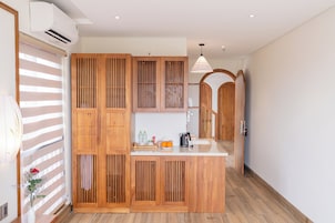 Cozinha moderna com armários de madeira, ilha central e luminária pendente.