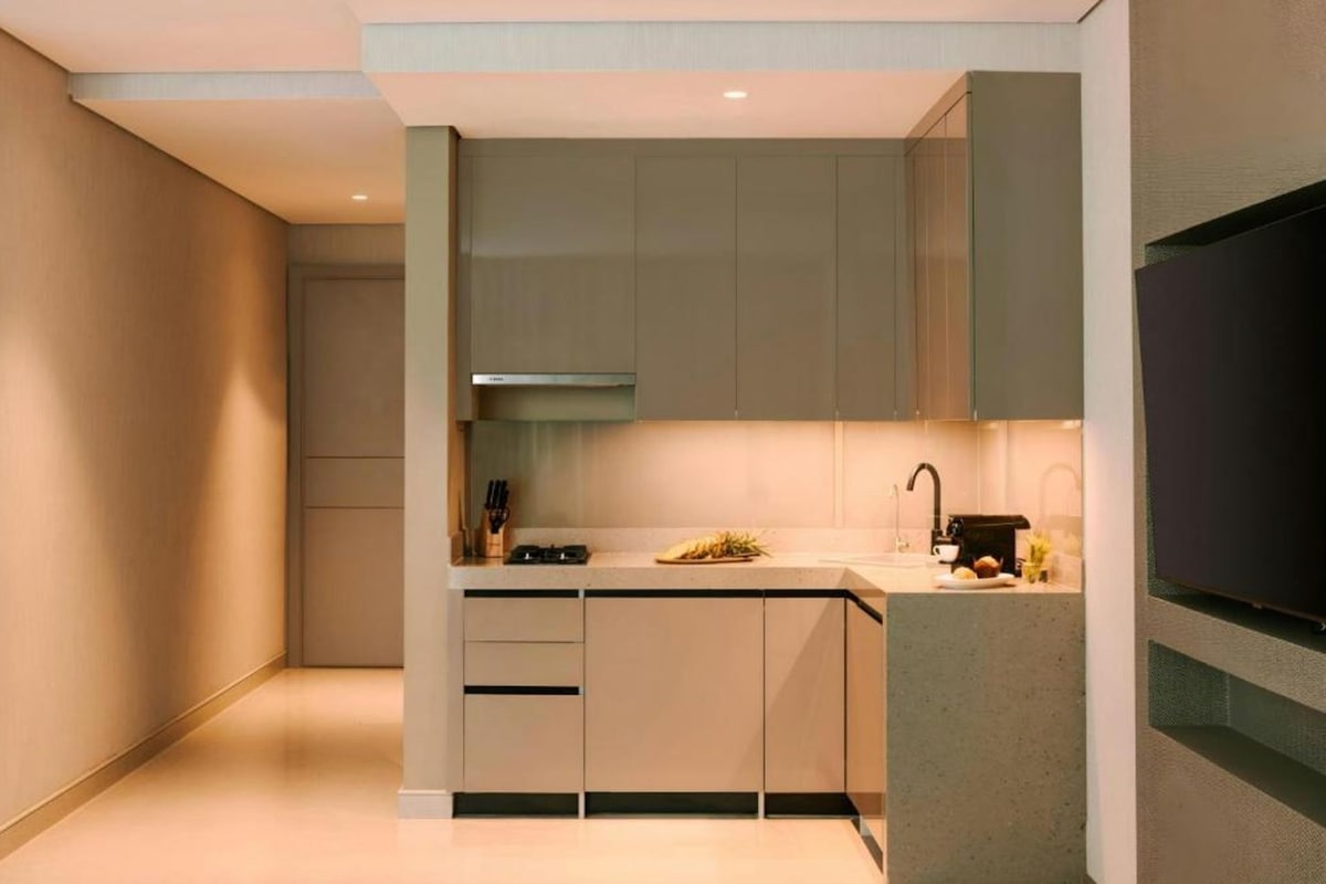 Uma cozinha moderna com ilha central, armários embutidos e bancada elegante.