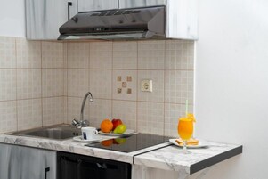 Um frigorífico, uma placa de cozinha, utensílios de cozinha 