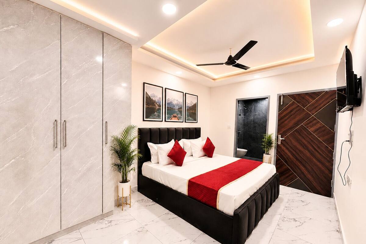 Quarto moderno com cama, guarda-roupa, ventoinha no teto e obras de arte.
