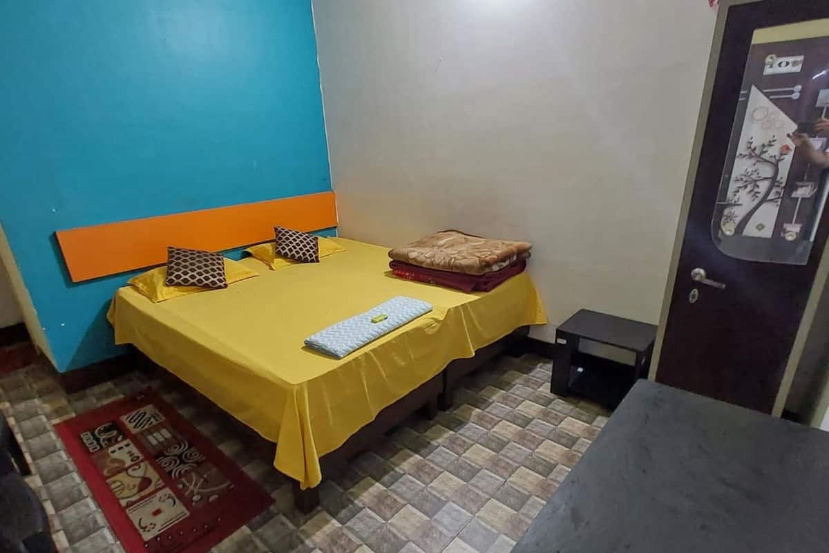 Quarto pequeno com cama, mesa e porta.