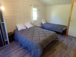 Quarto com duas camas, uma janela e uma porta.