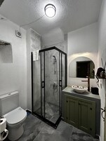 Quarto Duplo Deluxe, vista para o pátio | Casa de banho | Um polibã, um secador de cabelo, chinelos, toalhas fornecidas