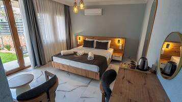 Quarto de hotel com cama, escrivaninha, cadeira, mesa redonda e um espelho grande.