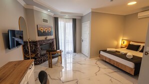 Quarto de hotel moderno com piso de mármore, TV de tela plana, escrivaninha de madeira, cama com cabeceira e uma janela grande com cortinas.