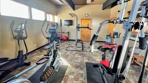 Uma academia com esteiras, elípticos e equipamentos de musculação.