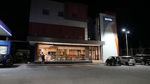 Um hotel com fachada moderna, entrada visível e placa indicando o nome do hotel.