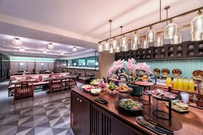 Um restaurante moderno com um bar central, arranjos de assento e uma decoração com orquídeas.