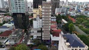 Um edifício alto com vários andares, cercado por outros edifícios e ruas.