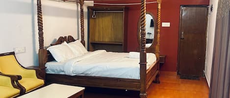 Uma cama de dossel com estrutura de madeira e um ventilador de teto acima.