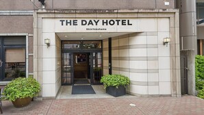 Entrada de um hotel com uma placa indicando 'THE DAY HOTEL ShinYokohama'.