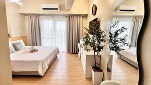 Quarto de hotel com uma cama, mesa de cabeceira com uma planta e uma cadeira.
