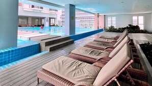 Uma área à beira da piscina com espreguiçadeiras e piscina.