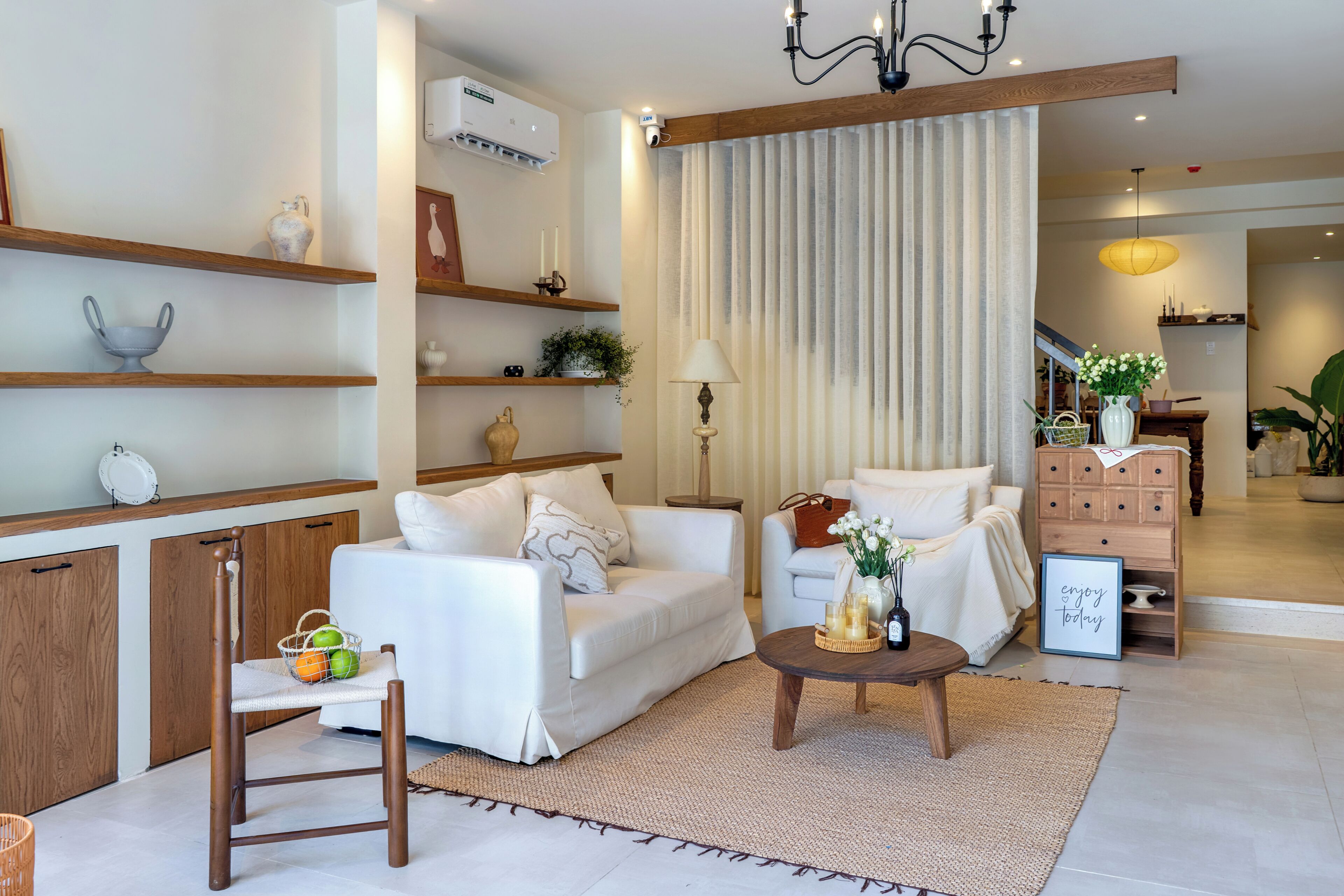 Uma sala de estar moderna com sofá, poltronas, mesa de centro e estante.