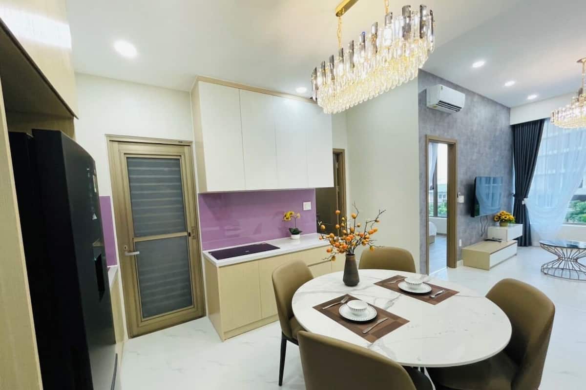 Uma cozinha moderna com forno embutido, uma área de refeições com mesa redonda e um candelabro.