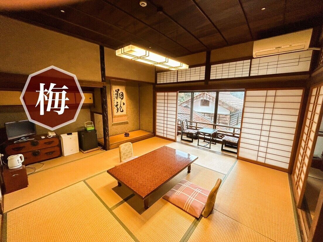 Um quarto japonês tradicional com tatames, uma mesa baixa e portas deslizantes.