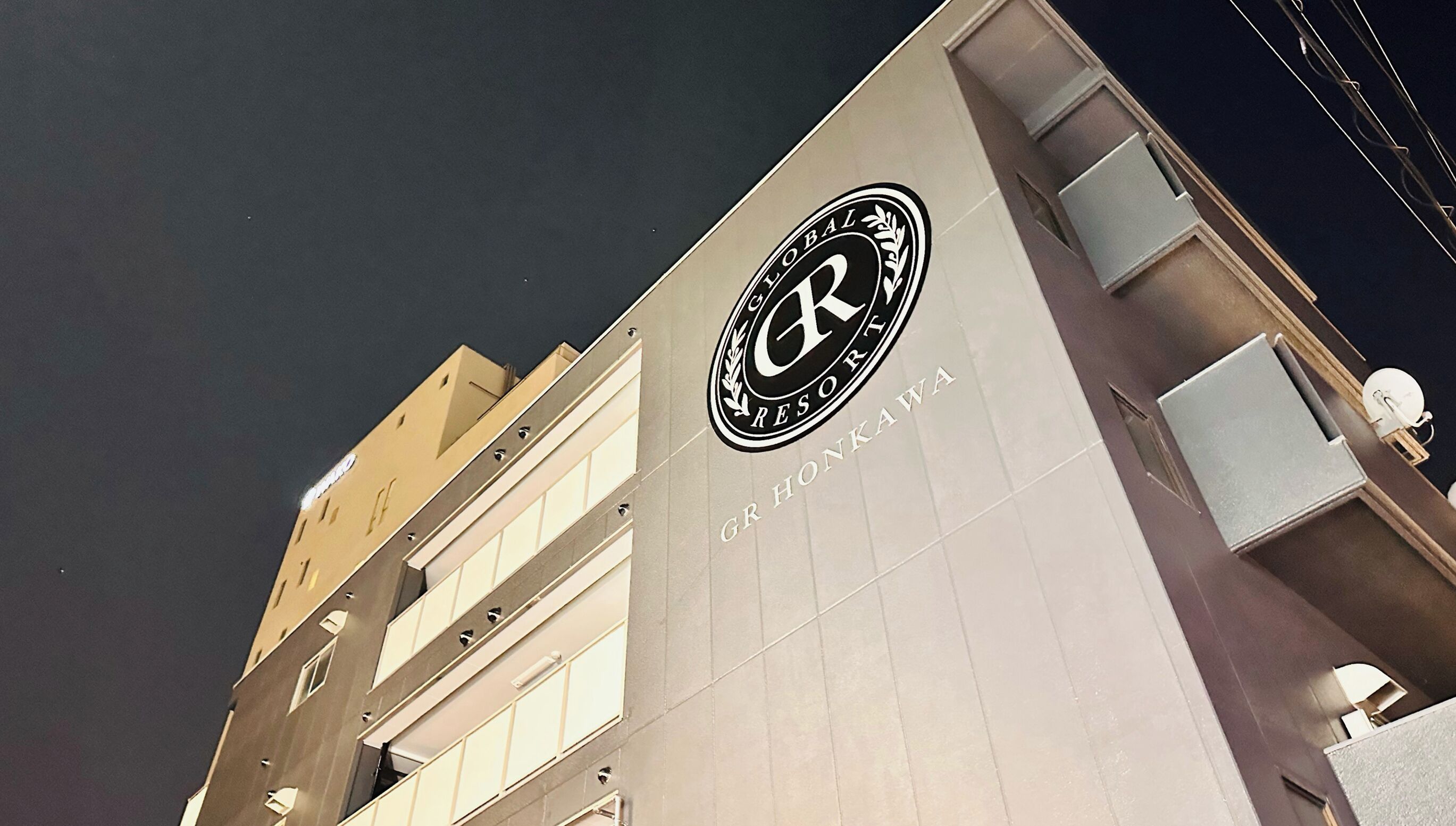 Um edifício com um grande logotipo e o texto 'GR HONKAWA RESORT' em sua fachada.