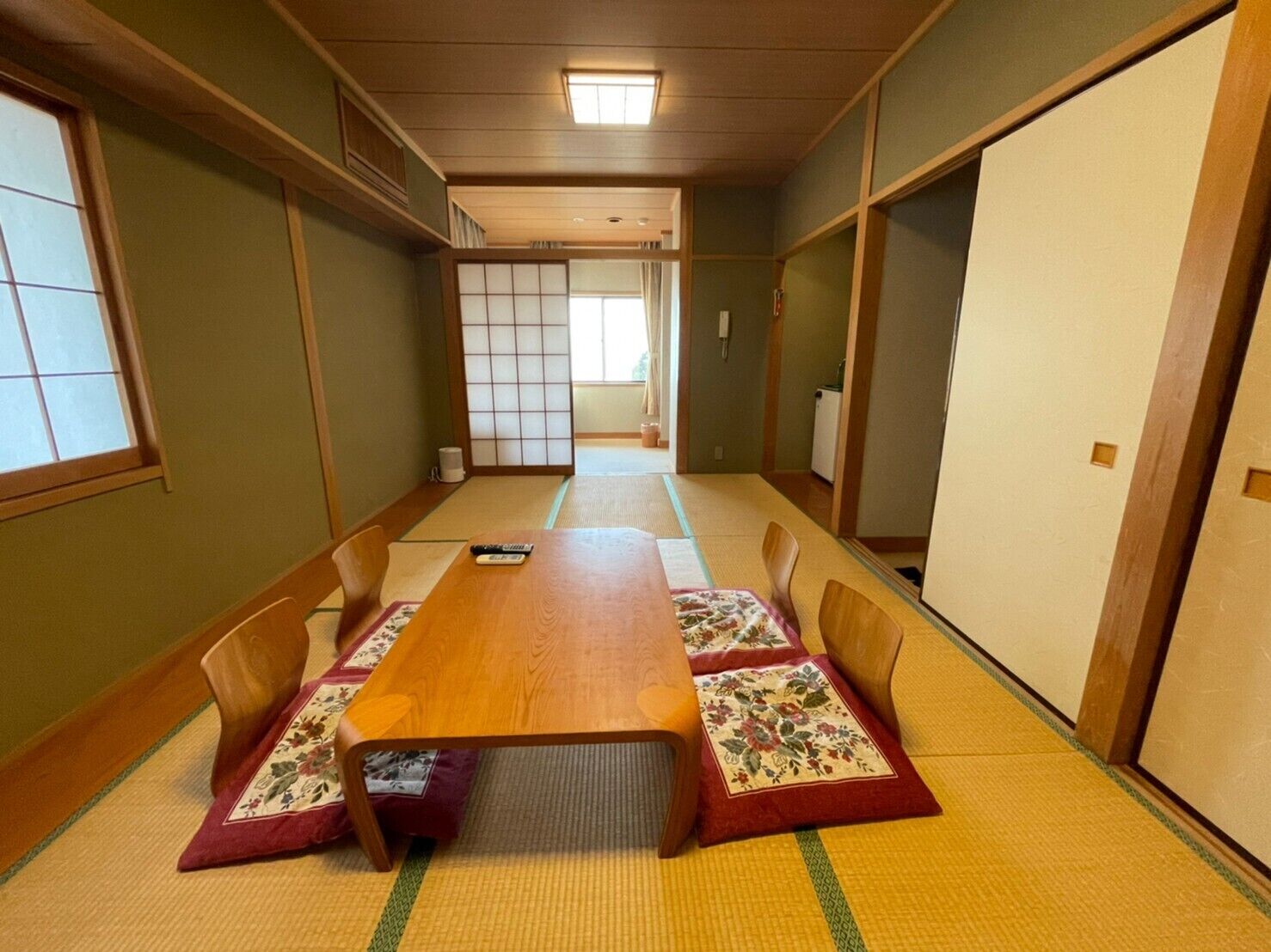Um quarto japonês tradicional com tatames, uma mesa de madeira e painéis shoji.