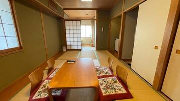 Um quarto japonês tradicional com tatames, uma mesa de madeira e painéis shoji.