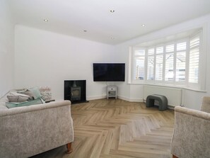 Uma sala de estar moderna com lareira, televisão e uma grande janela.