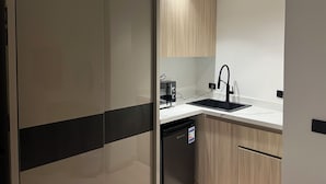 Uma cozinha moderna com uma torneira preta, uma máquina de lavar louça e armários de madeira.