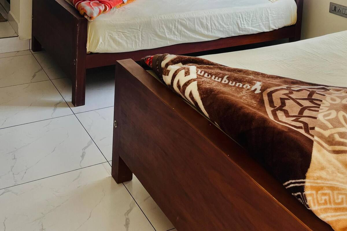 Quarto com cama, ventilador de teto, janela com grades e porta.