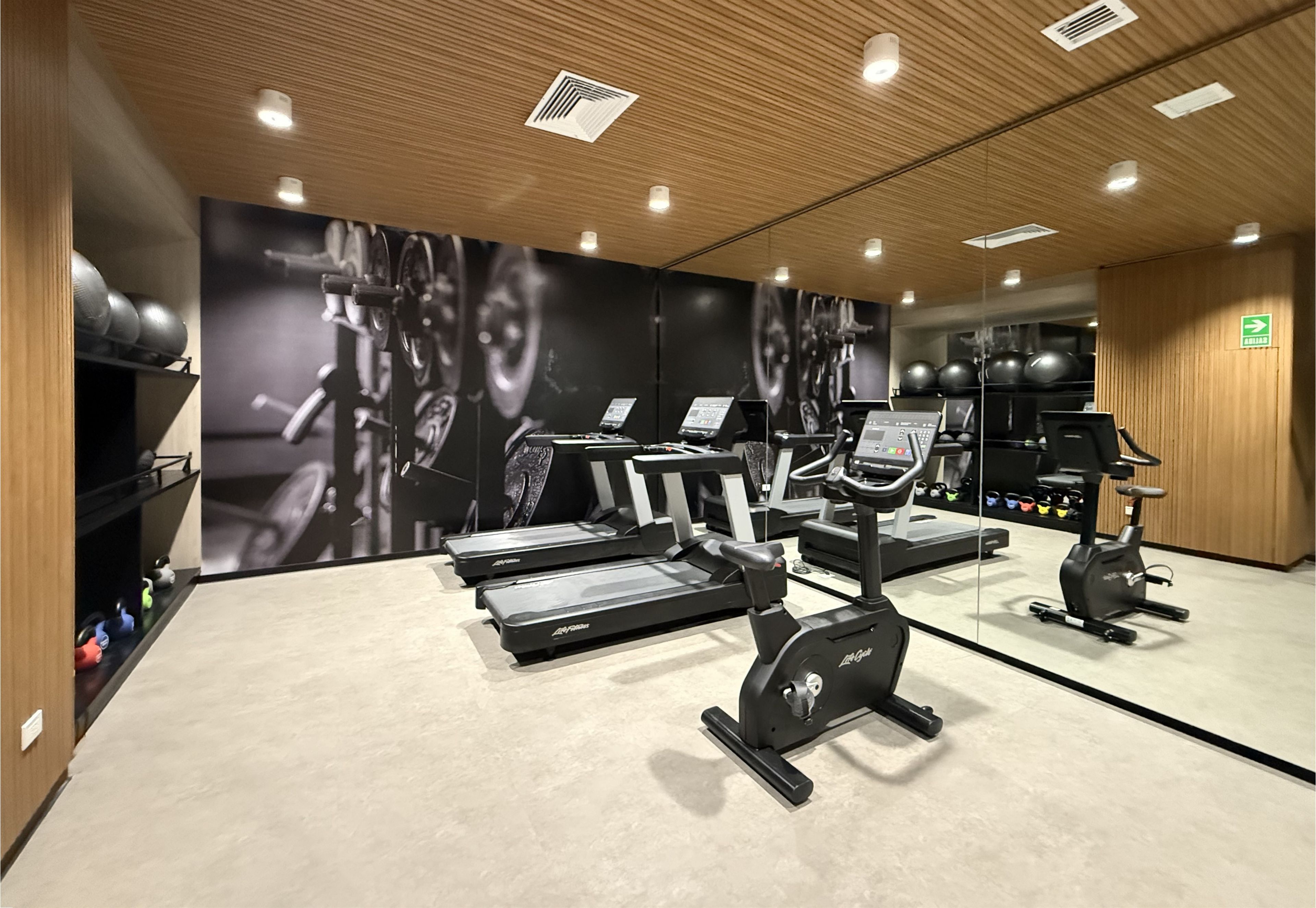 Academia com esteiras, bicicletas ergométricas e aparelhos de musculação.