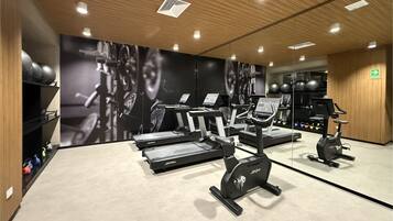 Academia com esteiras, bicicletas ergométricas e aparelhos de musculação.