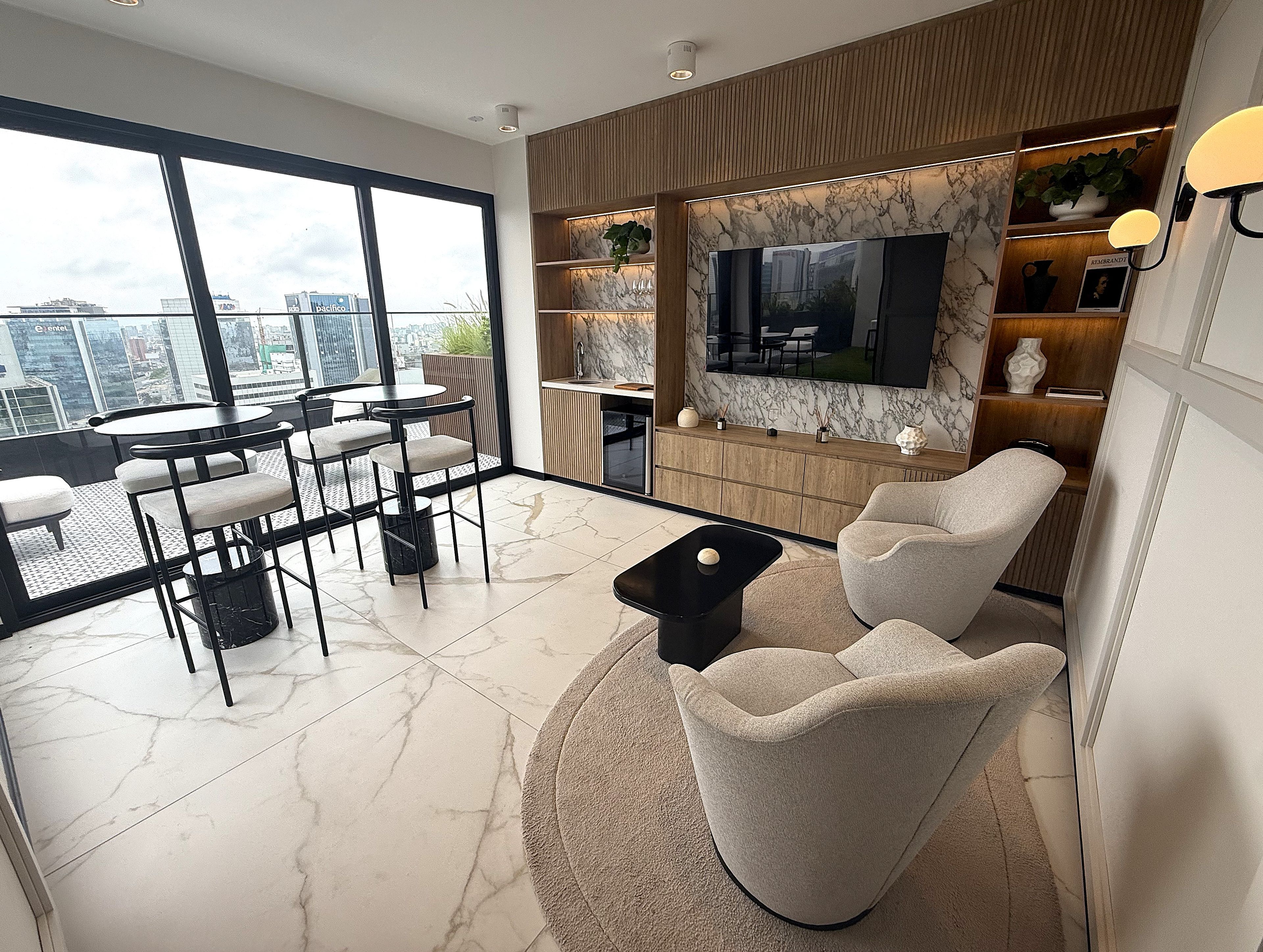 Uma sala de estar moderna com uma televisão grande, assentos confortáveis, um espaço de refeições e vista para a cidade.