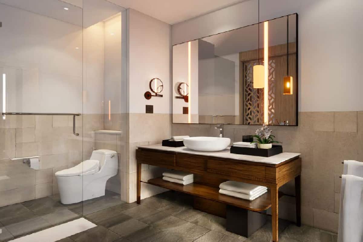 Uma casa de banho moderna com um espelho grande, lavatório branco e sanita.