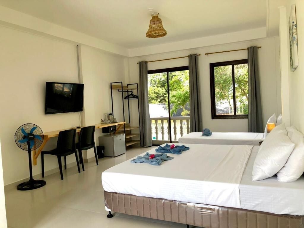 Quarto triplo standard, vista parcial para o mar | Cofres nos quartos, escrivaninha, cortinas blackout, Wi-Fi de cortesia