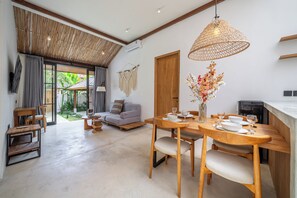 Um interior moderno com área de refeições, sofá e vista para o exterior.