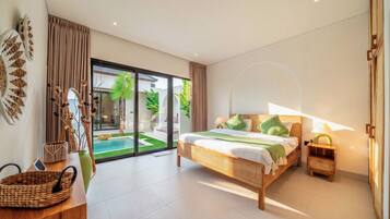 Quarto com cama, mesas de cabeceira, janela e vista para uma piscina.