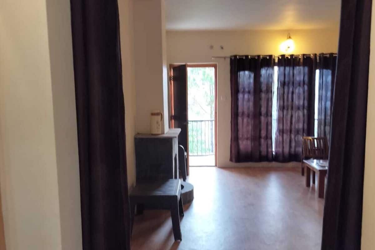 Uma sala de estar ampla com lareira, mesa de jantar e cadeiras.