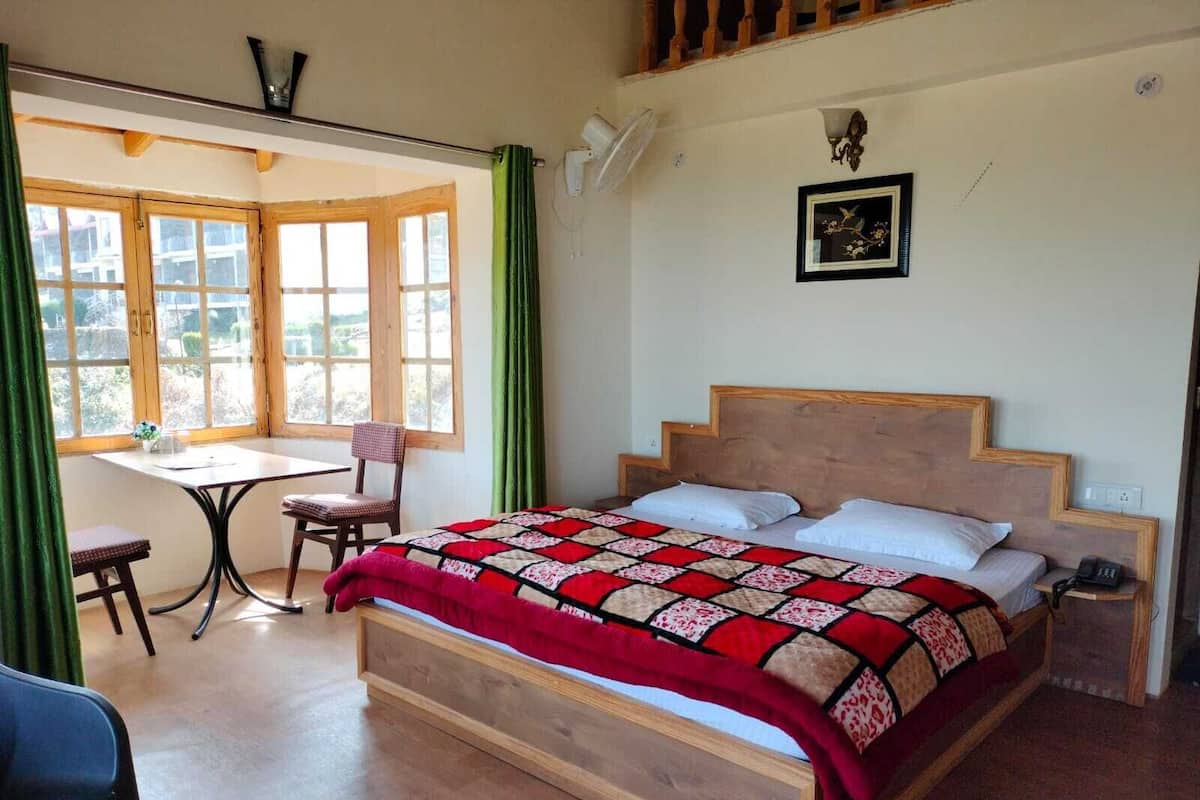 Quarto com uma cama de madeira, uma escrivaninha e uma cadeira.