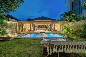 Uma casa moderna com piscina, varanda coberta e jardim bem cuidado.