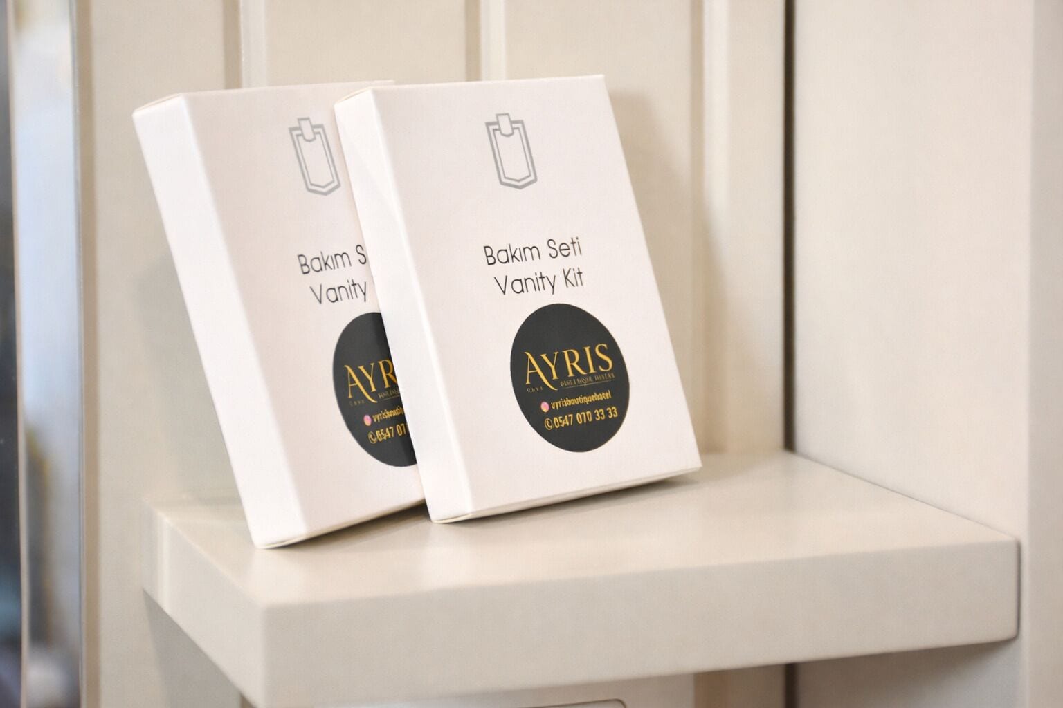 Duas caixas brancas rotuladas 'Bakm Seviy Vanity Kit', com logotipo e informações de contato.