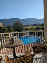 Uma varanda com vista para uma piscina e montanhas.